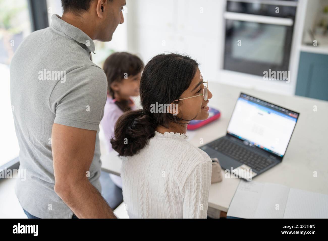 Father helping daughters doing homework Stock Photo - Alamy