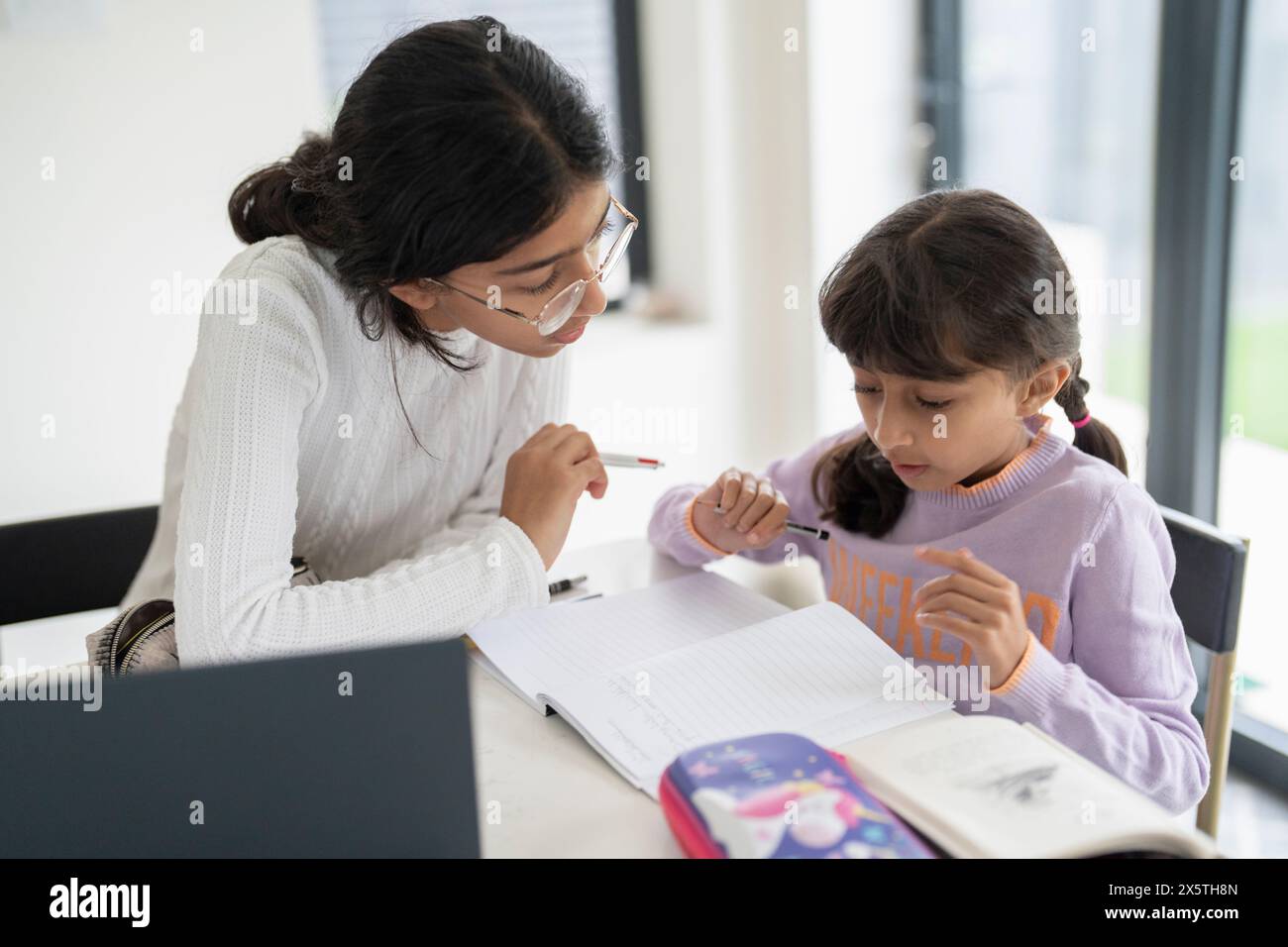 Girl helping little sister doing homework Stock Photo - Alamy