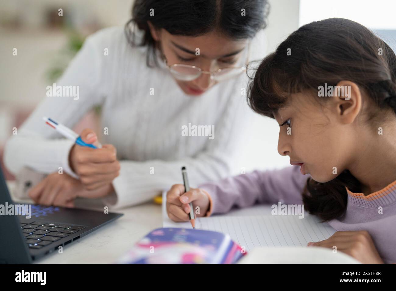 Girl helping little sister doing homework Stock Photo - Alamy