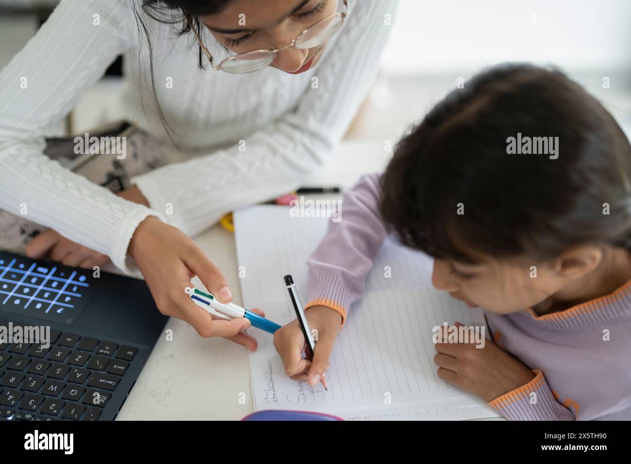 Girl helping little sister doing homework Stock Photo - Alamy