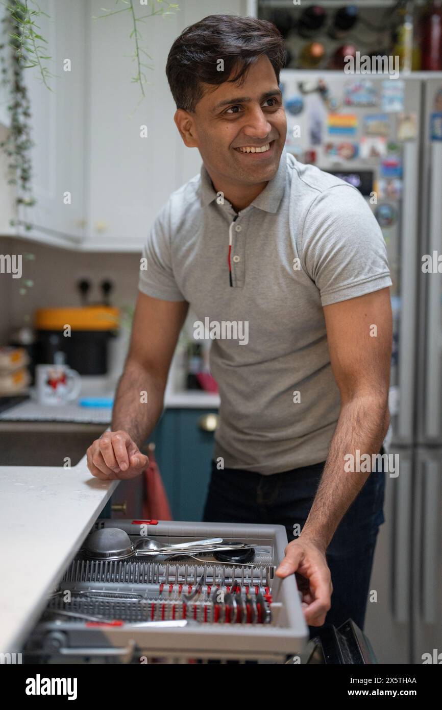 Man putting dishes into dishwasher Stock Photo - Alamy
