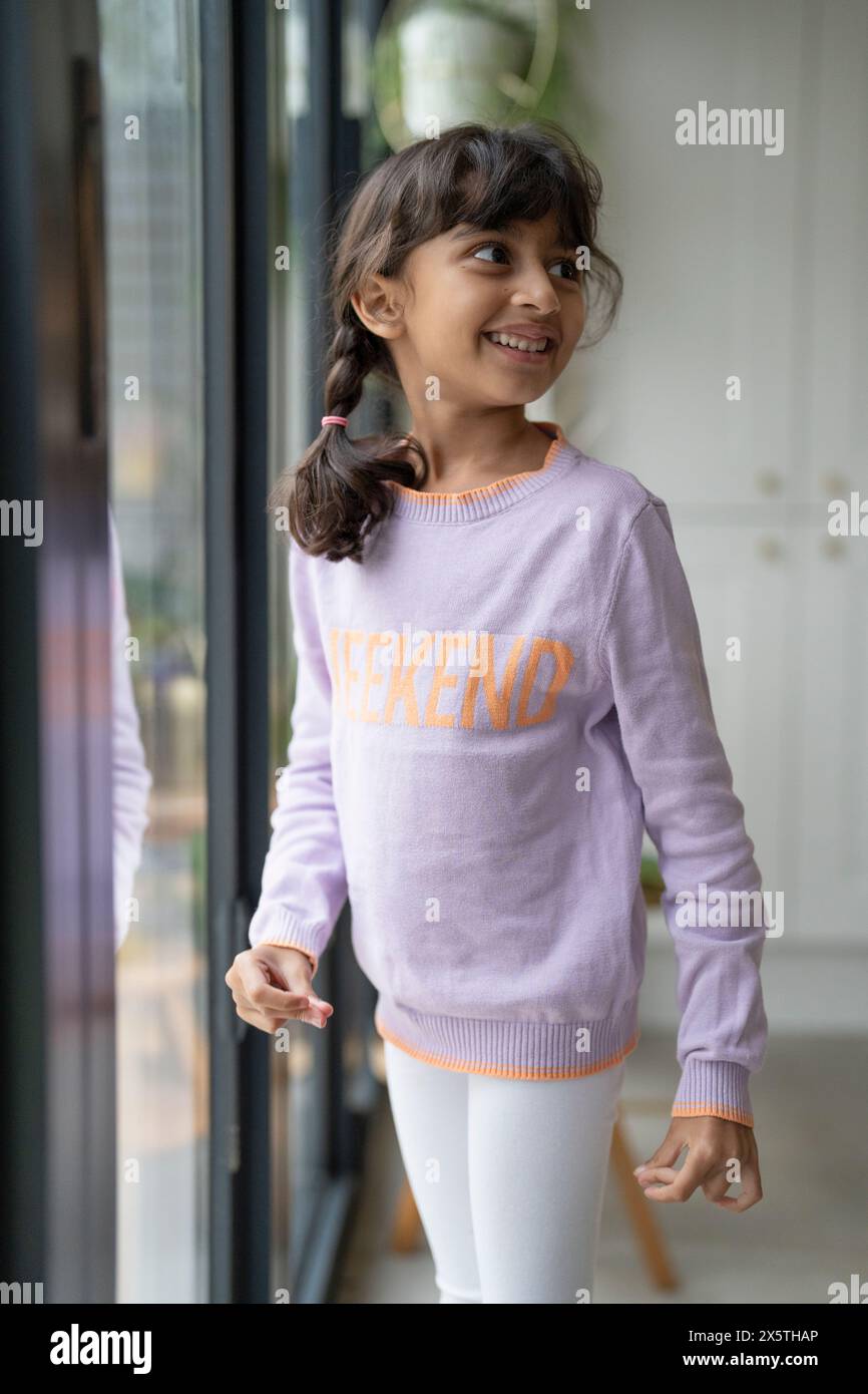 Little girl standing near window Stock Photo - Alamy