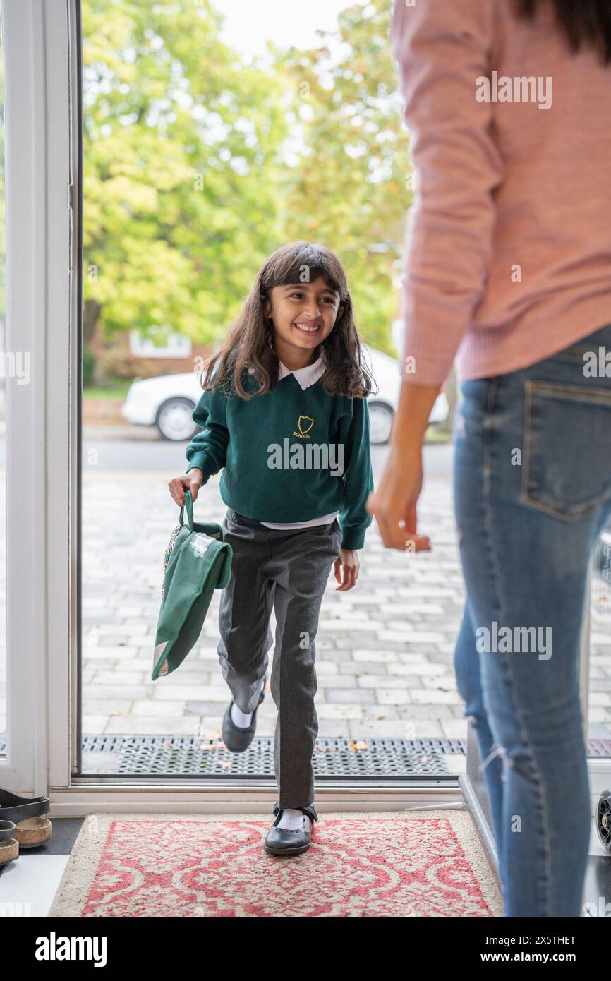 Schoolgirl entering house after returning from school Stock Photo - Alamy
