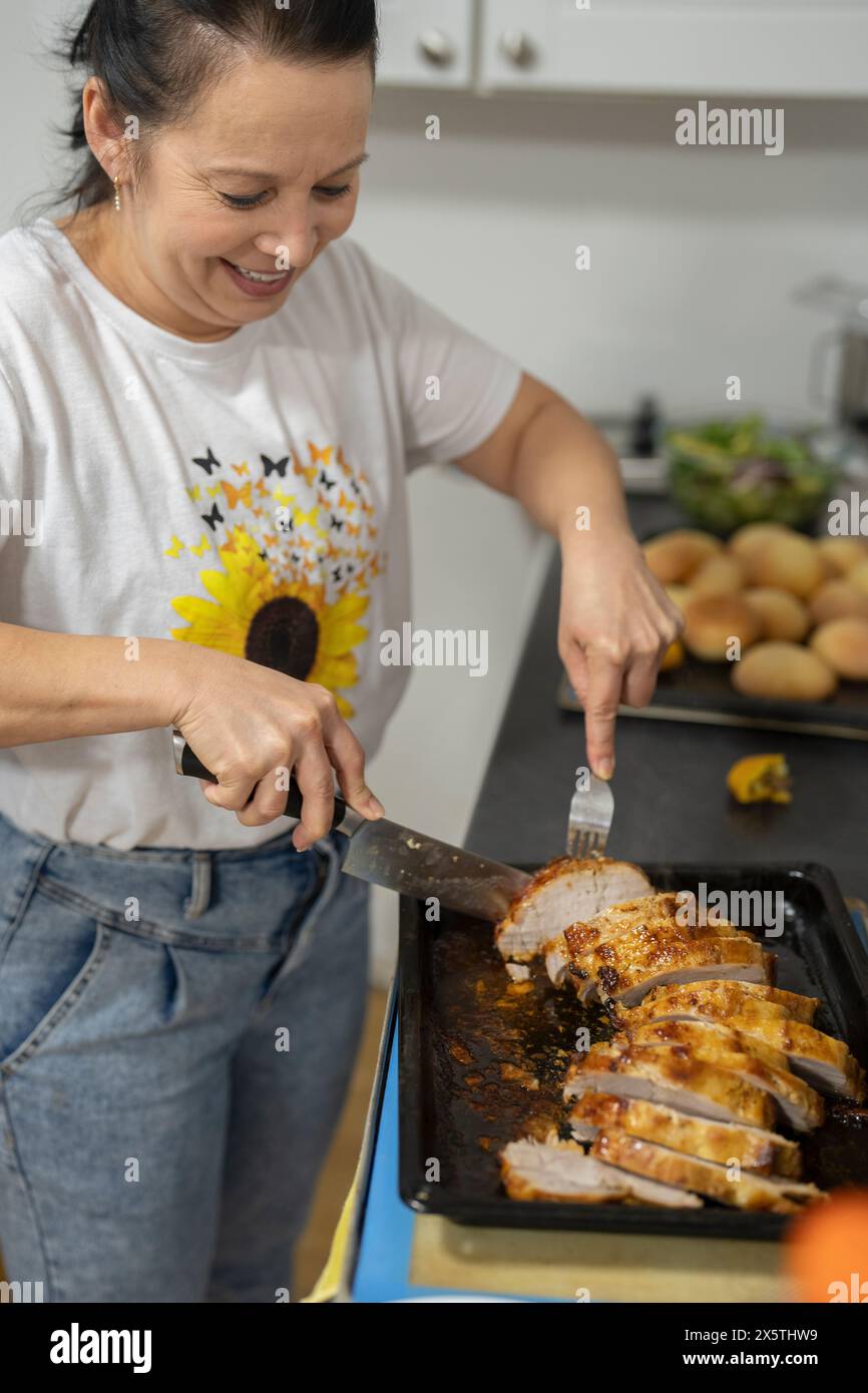 Woman slicing cooked meat on kitchen counter Stock Photo - Alamy