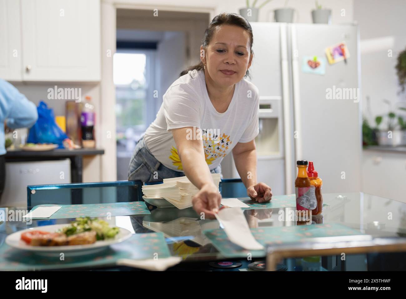 Woman preparing dining table for lunch Stock Photo - Alamy