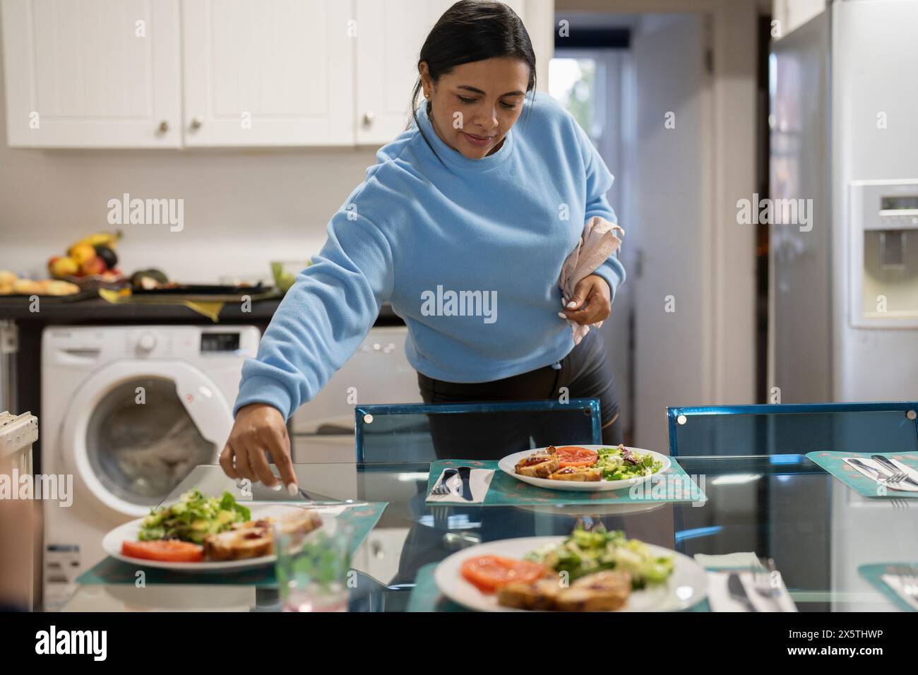 Woman bringing lunch to dining table Stock Photo - Alamy