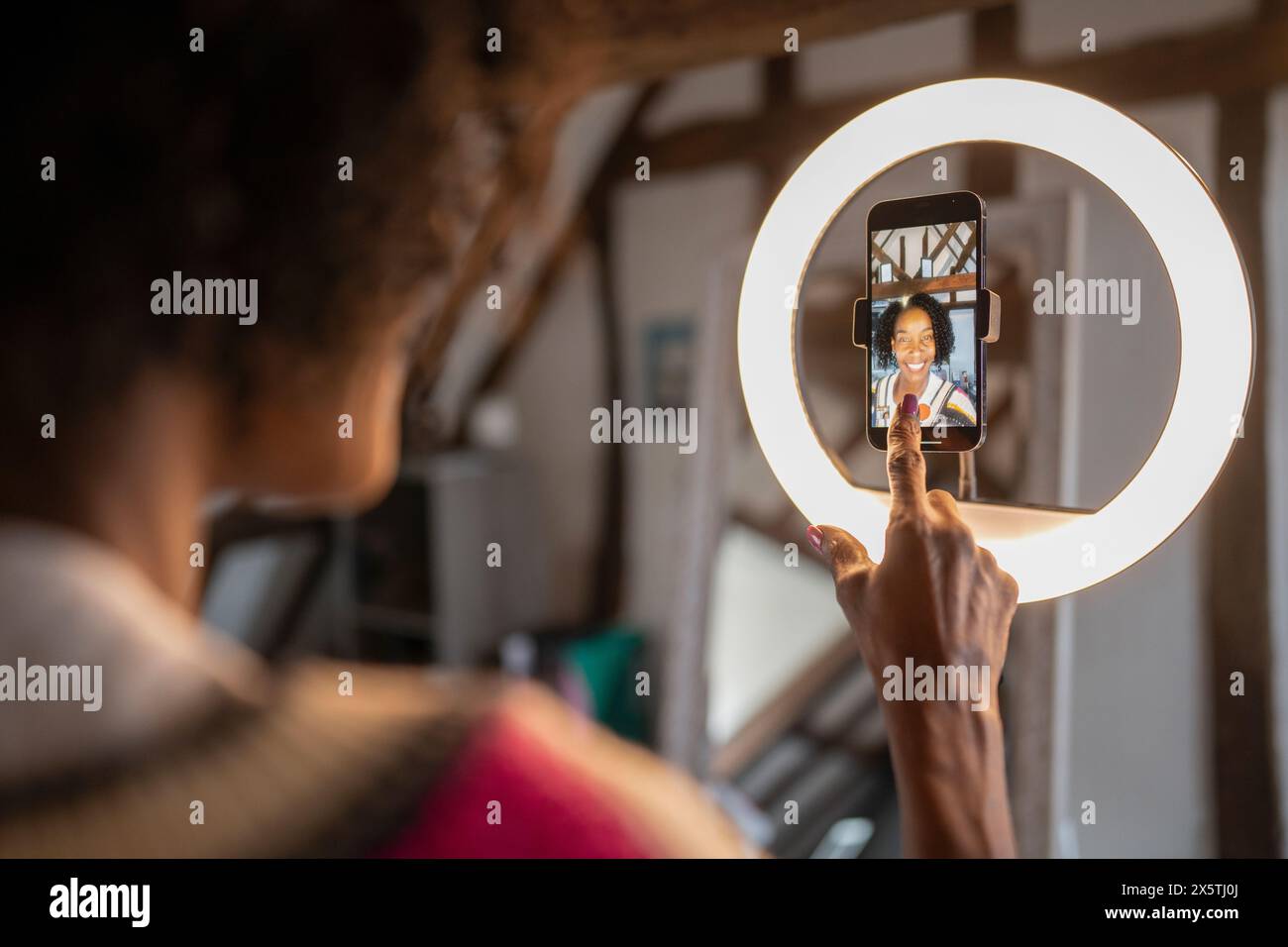 Woman recording video with smart phone at home Stock Photo - Alamy