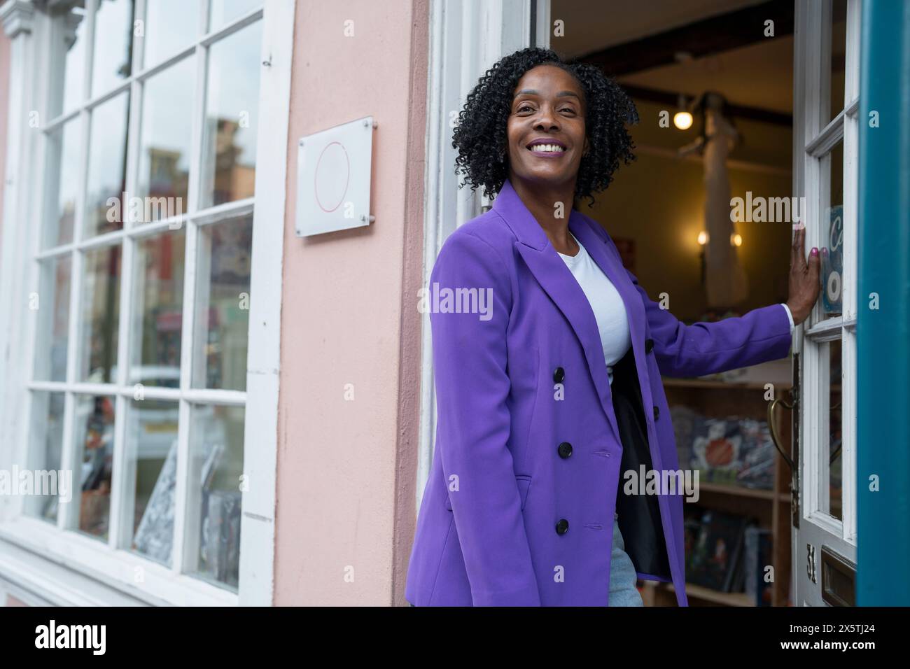 Portrait of female business owner walking into store Stock Photo - Alamy