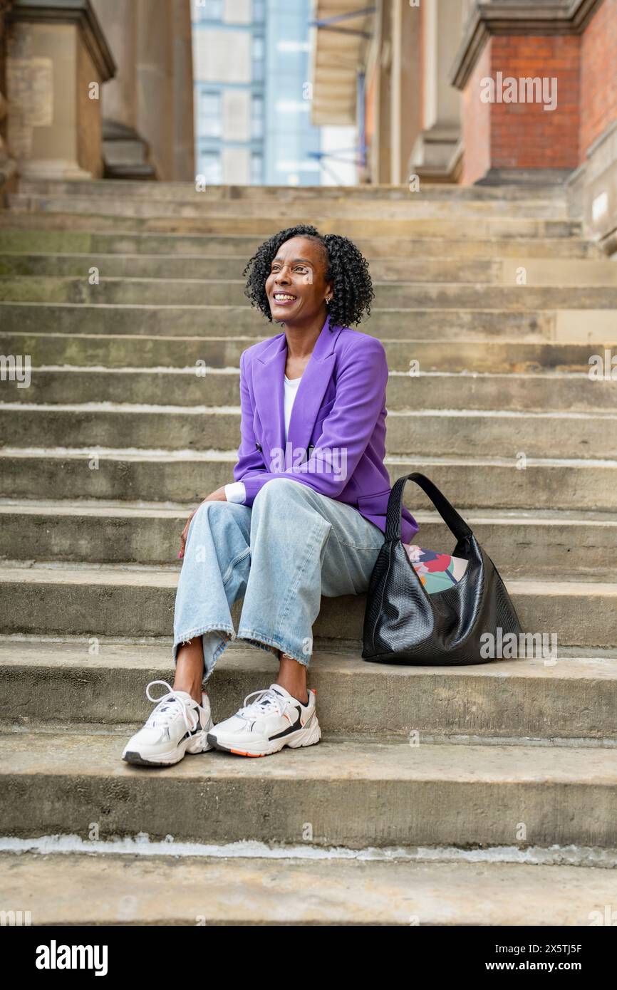 Woman sitting on steps hi-res stock photography and images - Alamy