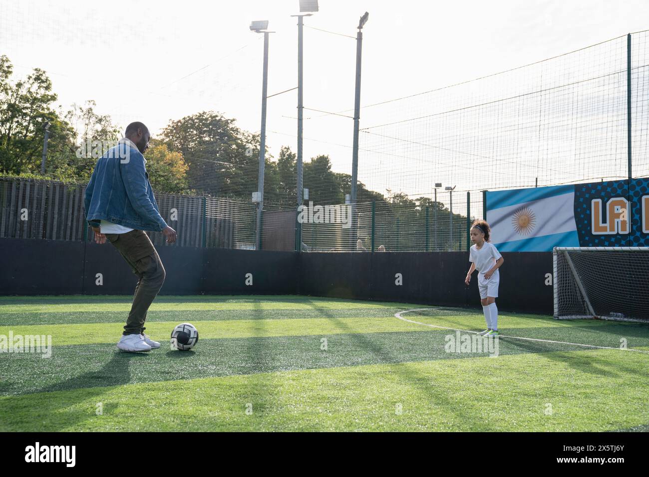 Father and daughter (6-7) playing soccer on soccer field Stock Photo ...