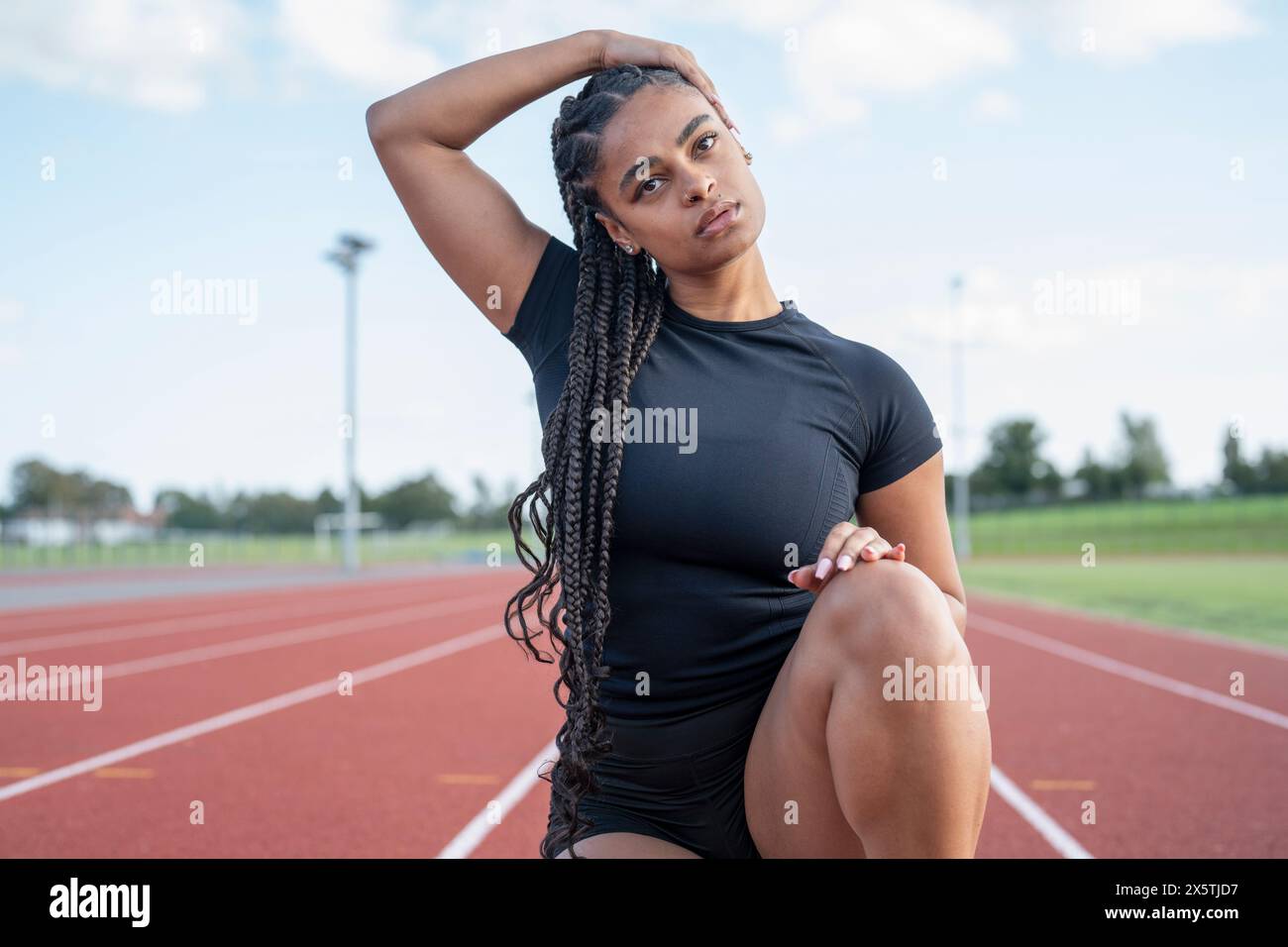 Female athlete stretching neck before run at stadium Stock Photo - Alamy