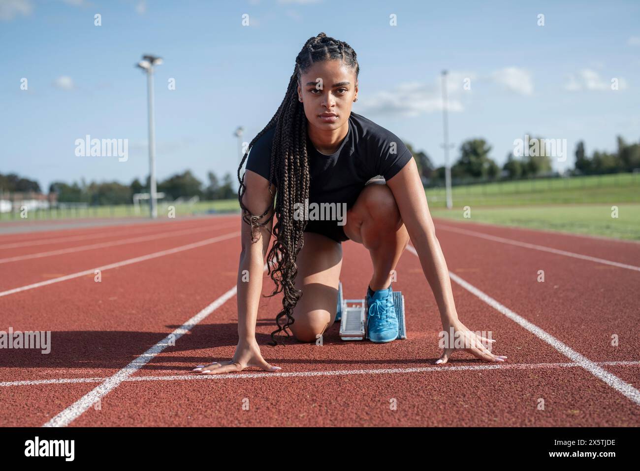 Female athlete preparing to run at stadium Stock Photo - Alamy