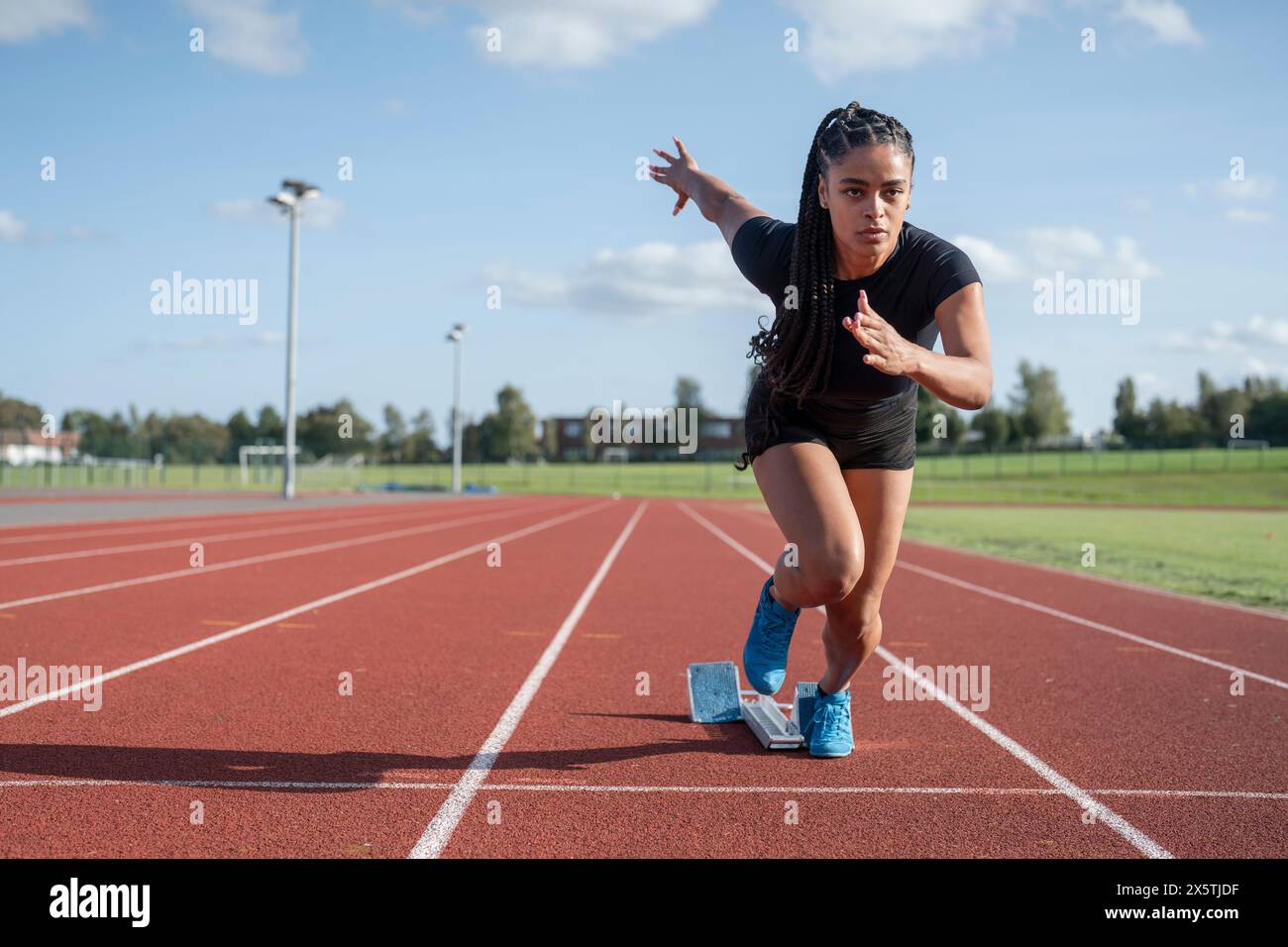 Female athlete sprinting off starting line at stadium Stock Photo - Alamy