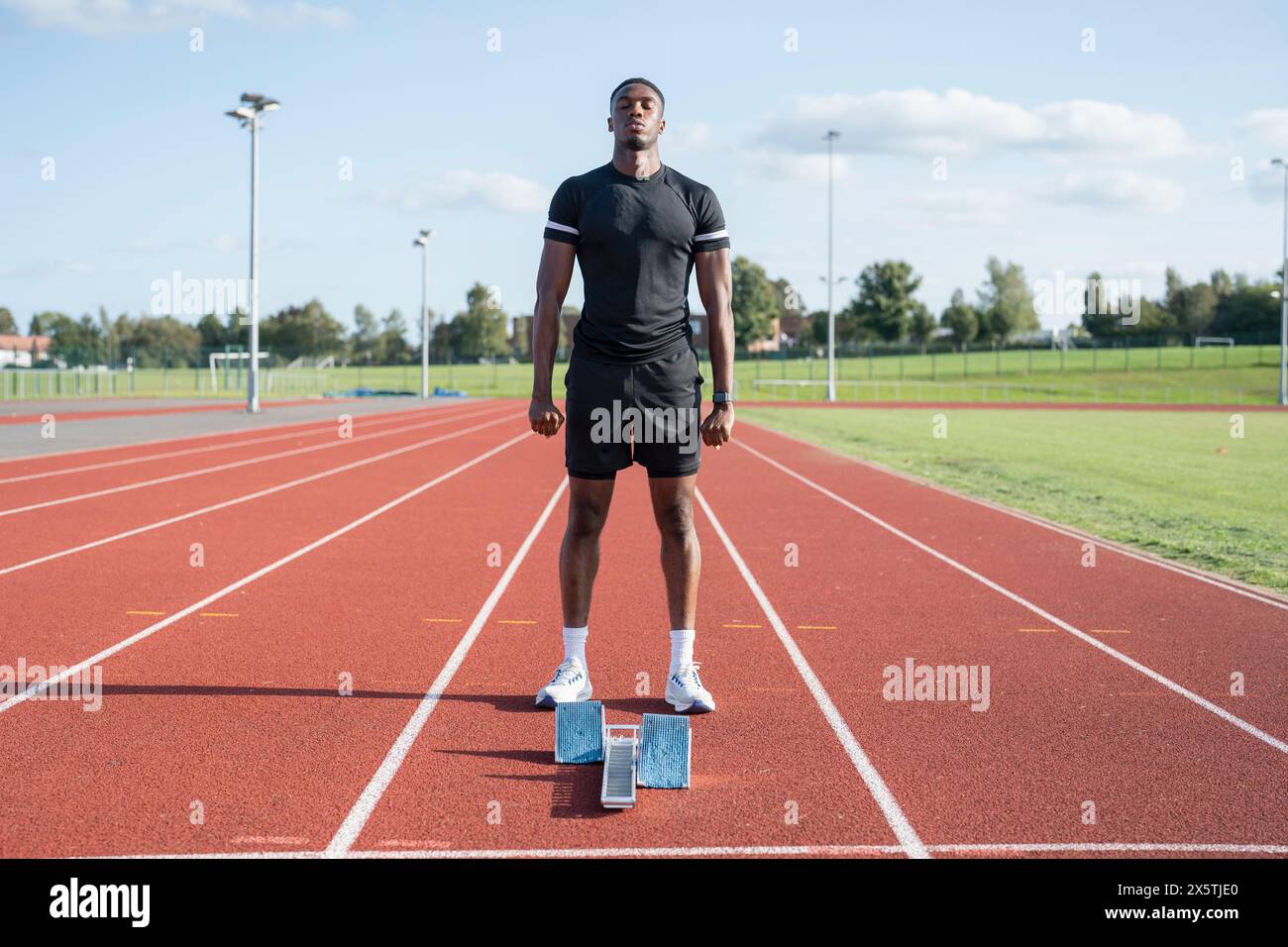 Athlete standing in front of starting line at running track Stock Photo ...