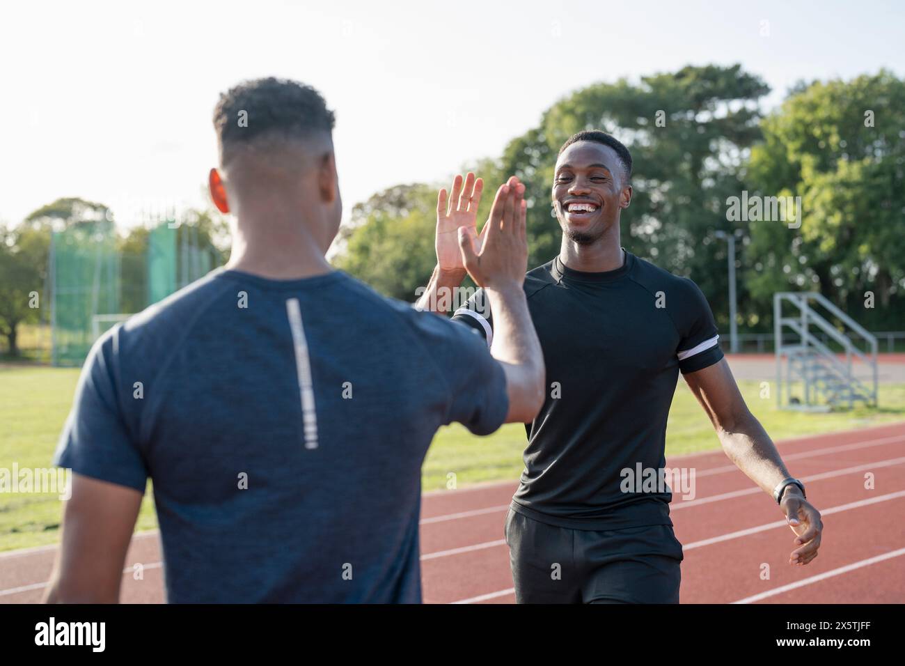 Portrait of two athletes doing high five Stock Photo - Alamy