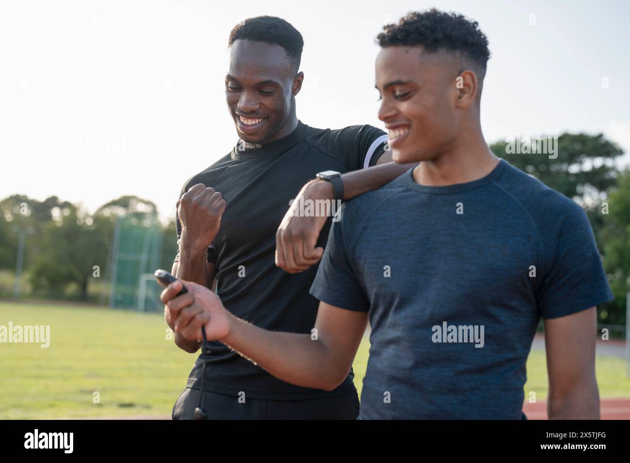 Portrait of two athletes checking stopwatch Stock Photo - Alamy
