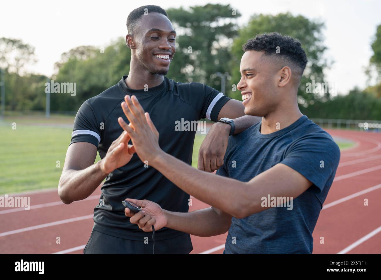Portrait of two athletes doing high five Stock Photo - Alamy