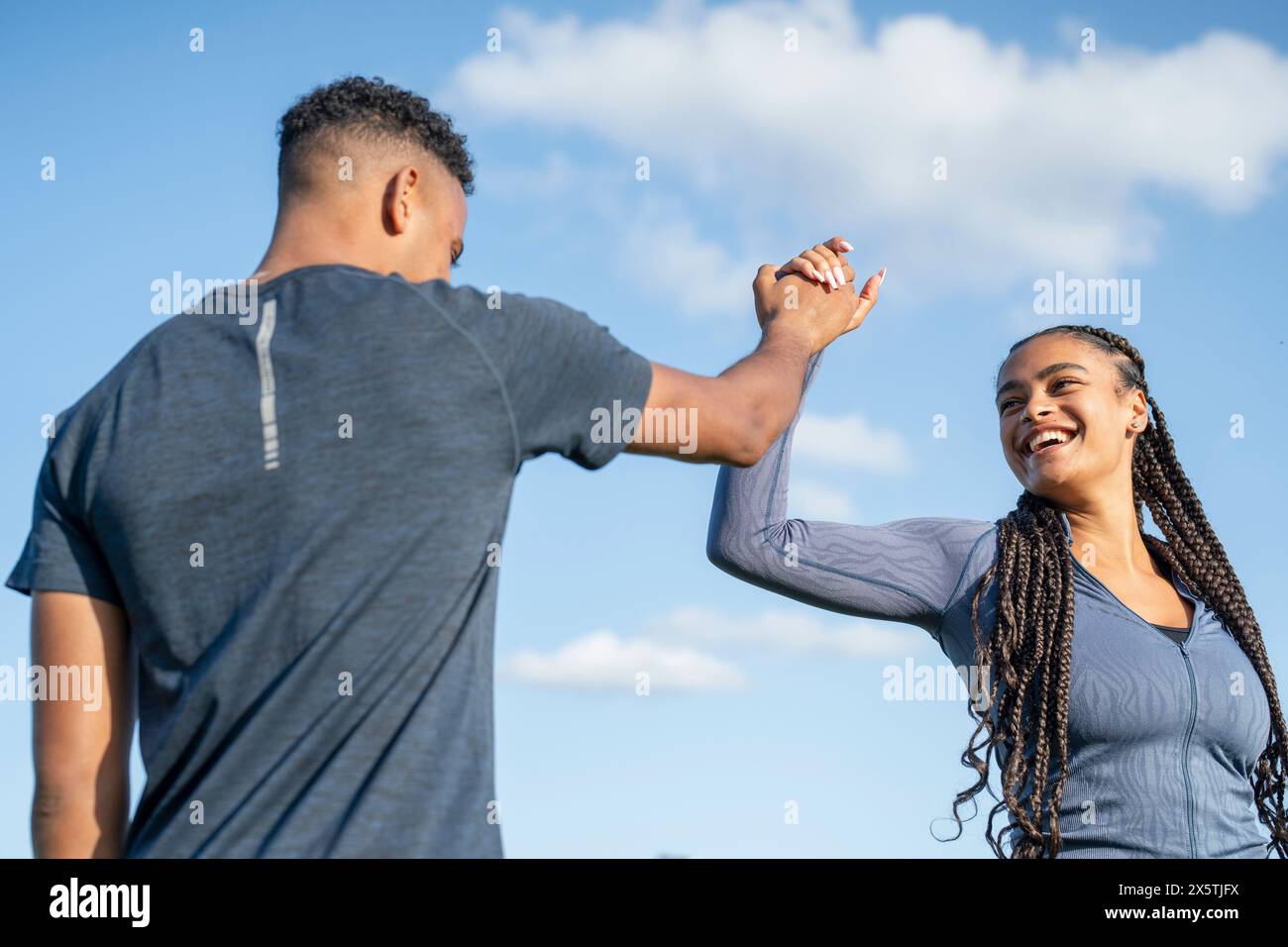Couple of athletes doing high five Stock Photo - Alamy