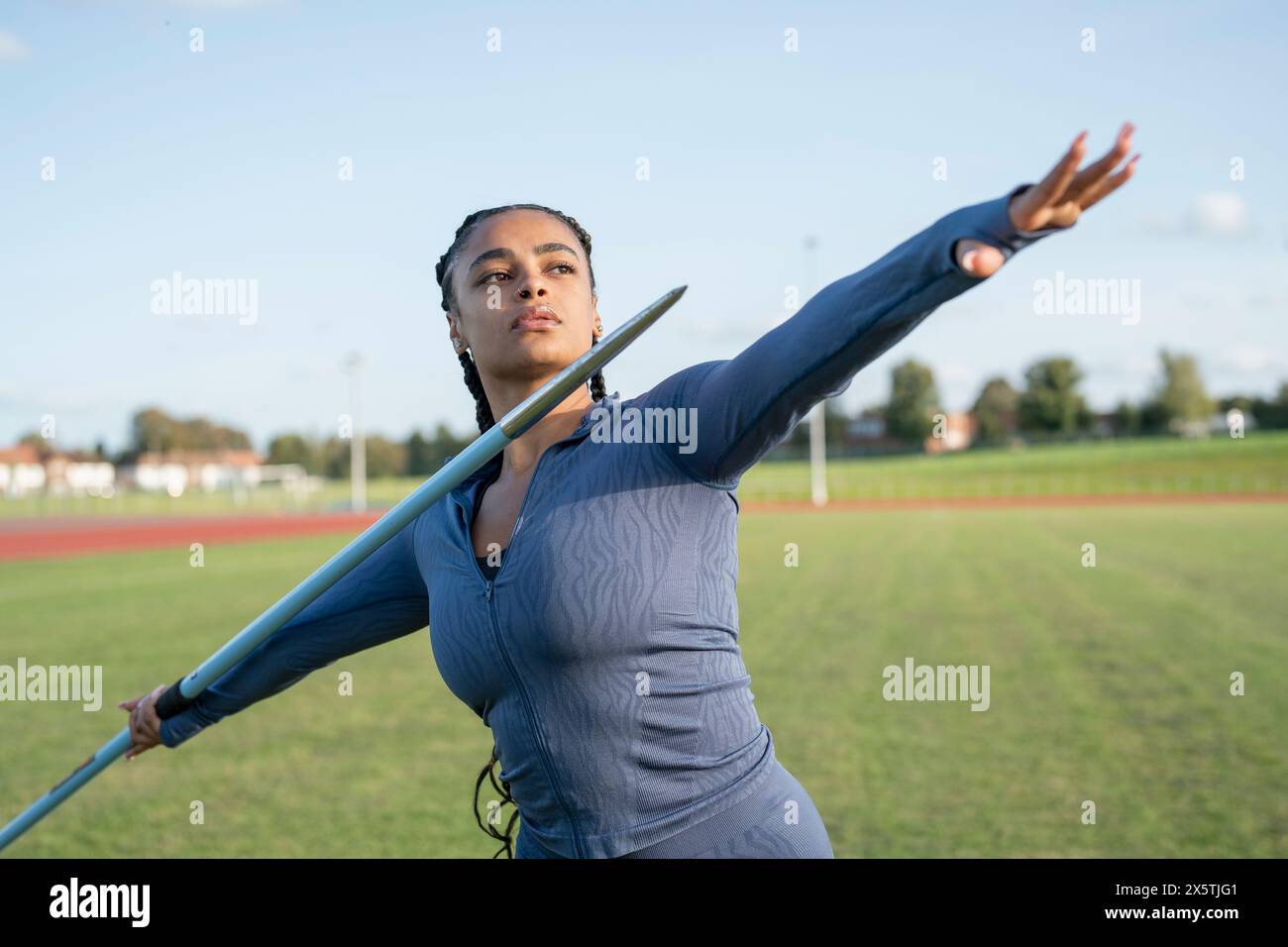 Portrait of female athlete throwing javelin Stock Photo - Alamy
