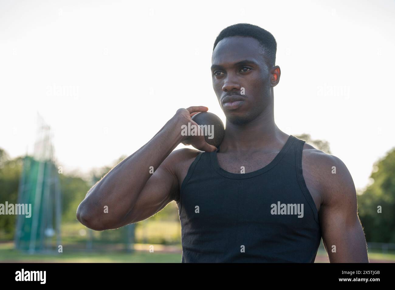 Portrait of athlete holding shot put Stock Photo - Alamy