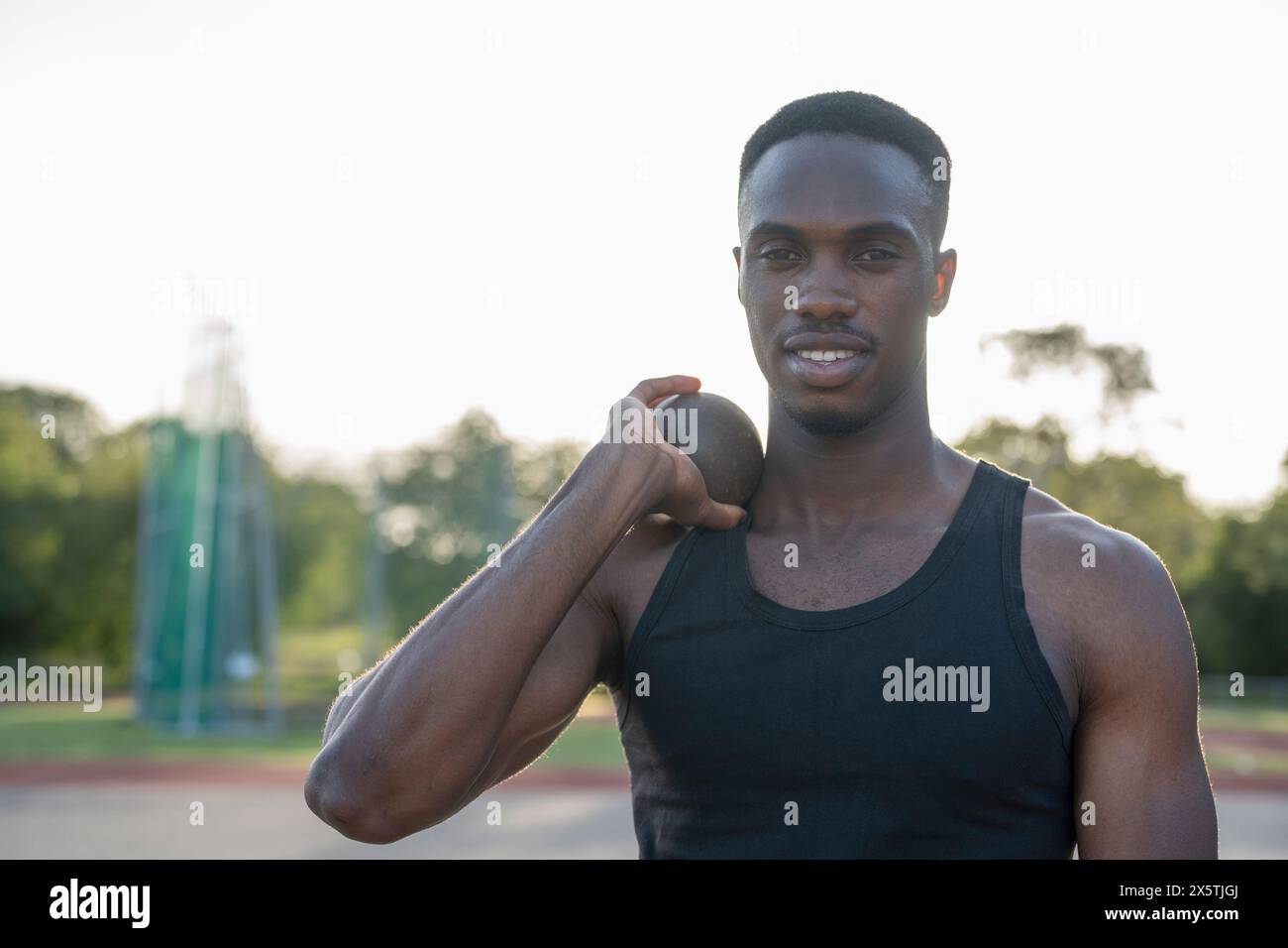 Portrait of athlete holding shot put Stock Photo - Alamy