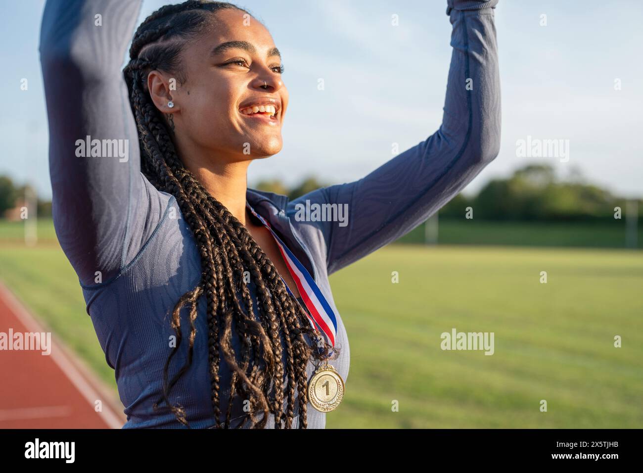 Portrait of female athlete celebrating with medal Stock Photo - Alamy