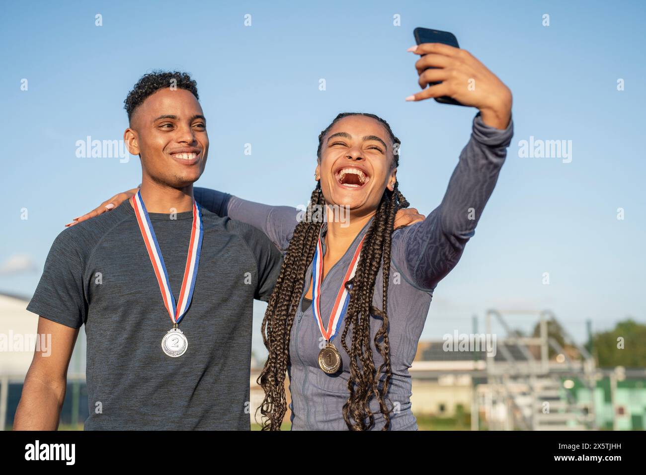 Portrait of male and female athlete celebrating with medals Stock Photo ...