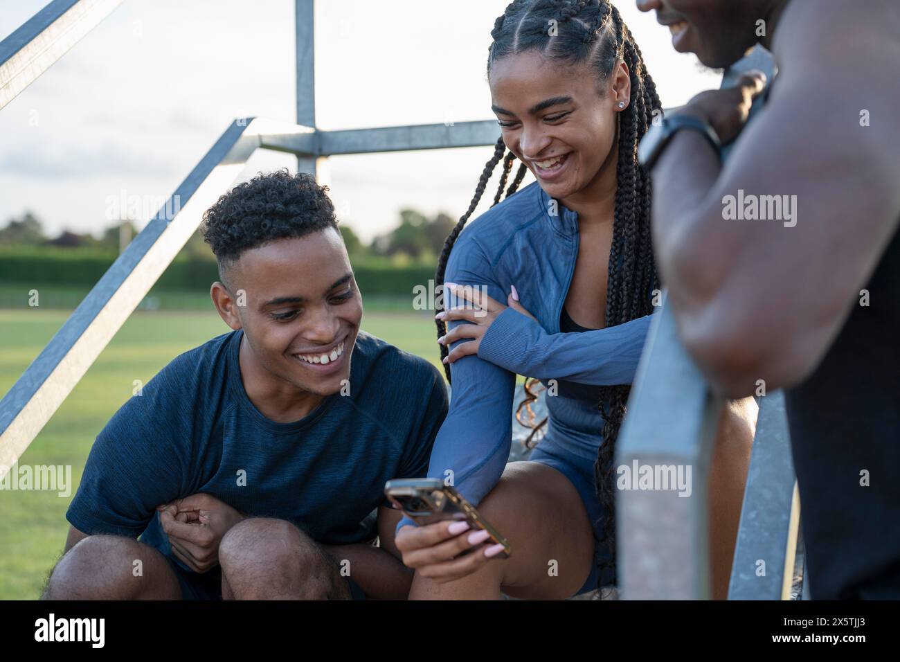 Group of athletes sitting on steps at stadium Stock Photo - Alamy