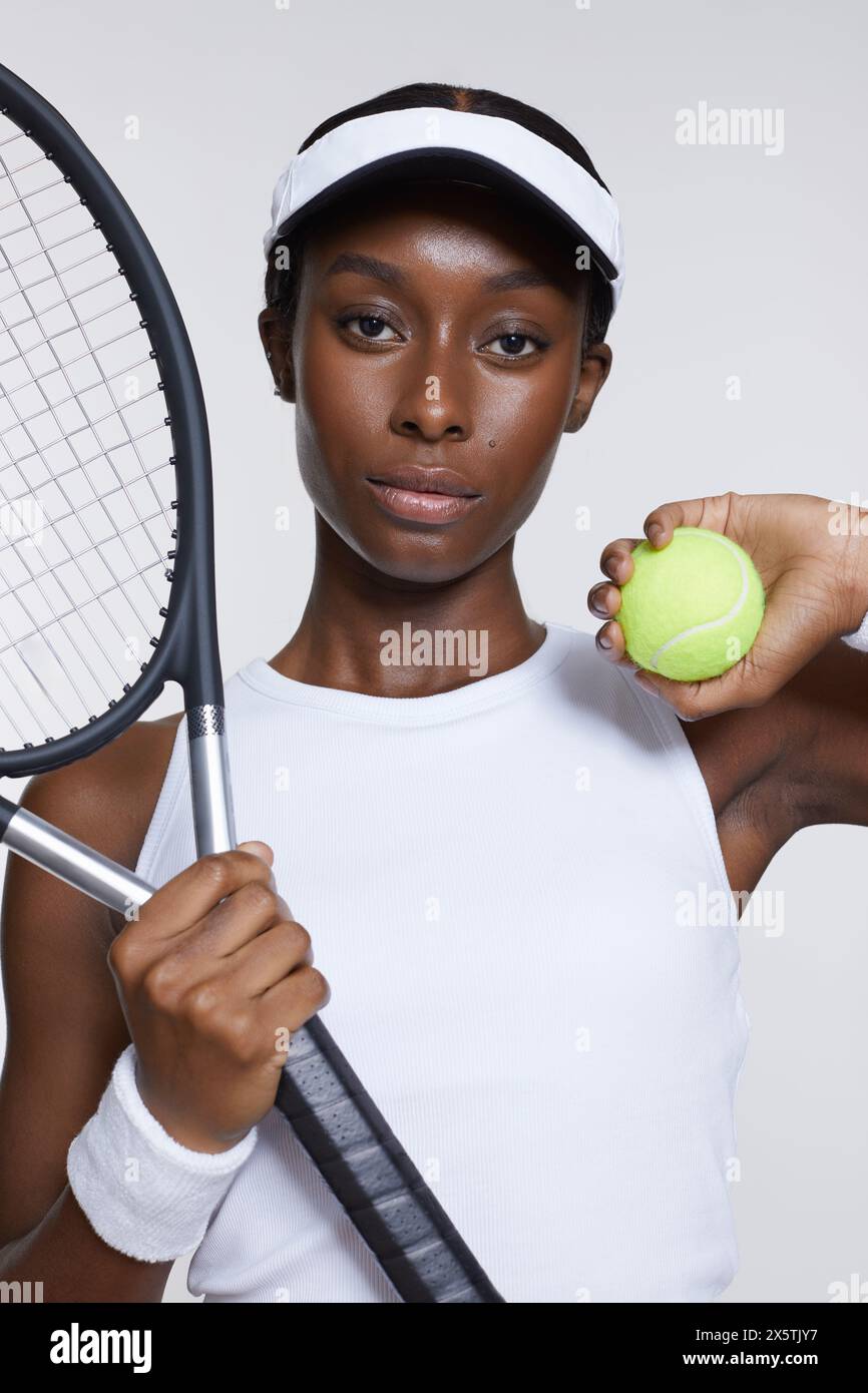 Studio portrait of athletic woman with tennis racket and ball Stock ...