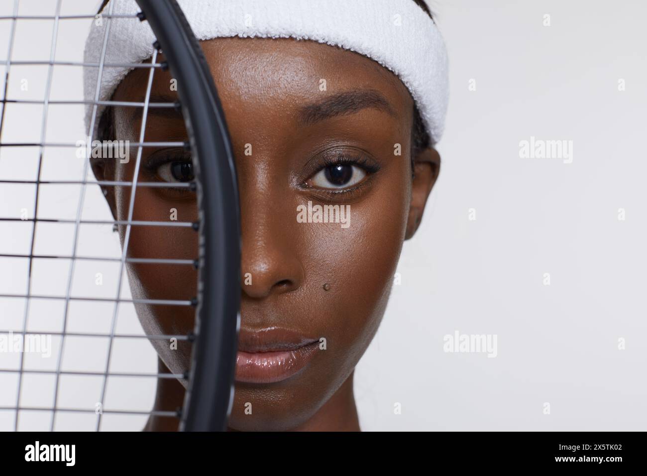 Studio portrait of athletic woman with tennis racket Stock Photo - Alamy