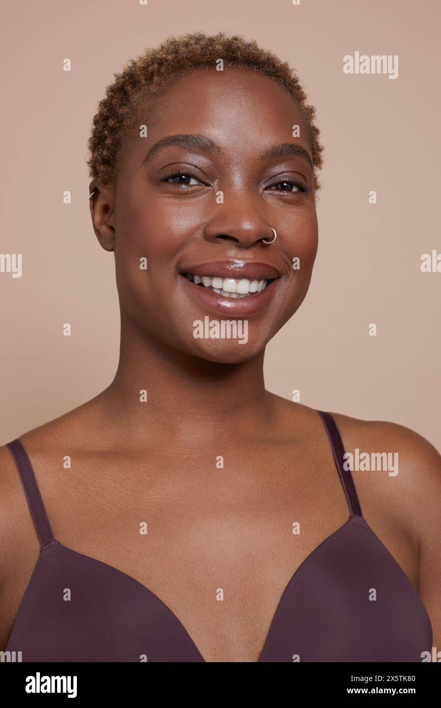 Studio portrait of smiling woman wearing bra Stock Photo - Alamy
