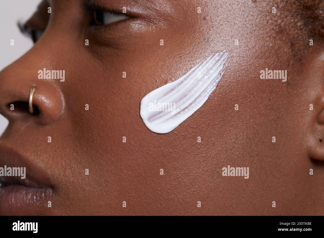Close-up of woman with face cream on cheek Stock Photo - Alamy