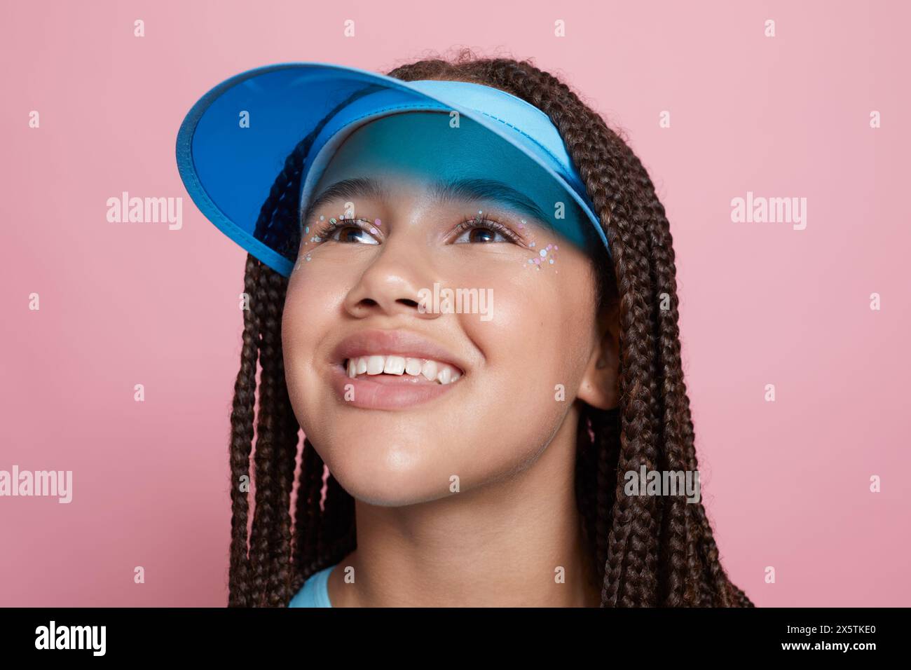 Studio portrait of smiling girl wearing sun visor Stock Photo - Alamy