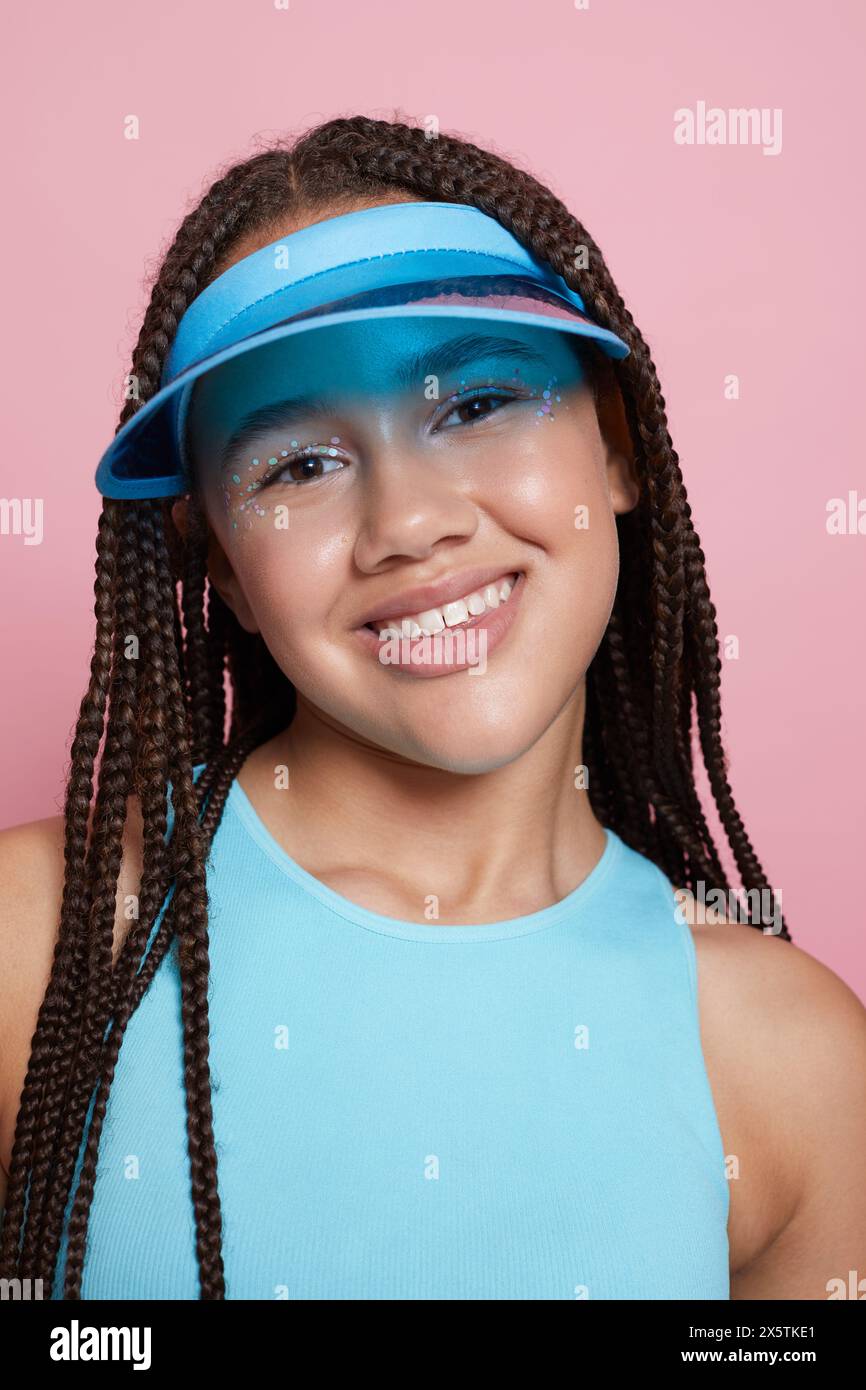 Studio portrait of smiling girl wearing sun visor Stock Photo - Alamy