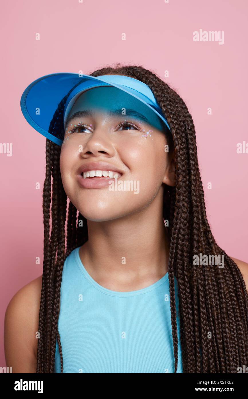 Studio portrait of smiling girl wearing sun visor Stock Photo - Alamy