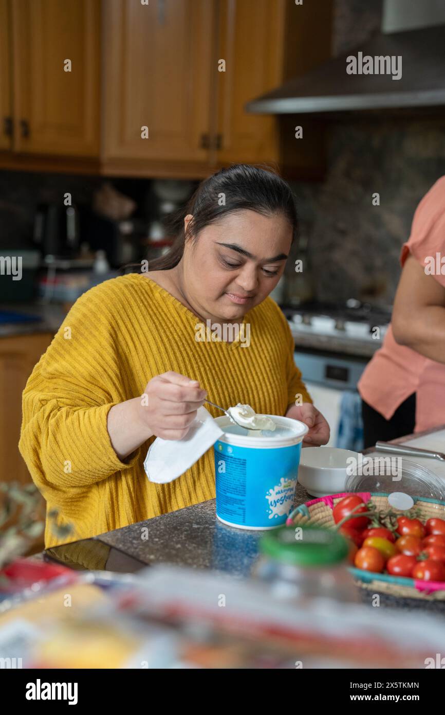 Young woman with down syndrome preparing food in kitchen Stock Photo ...