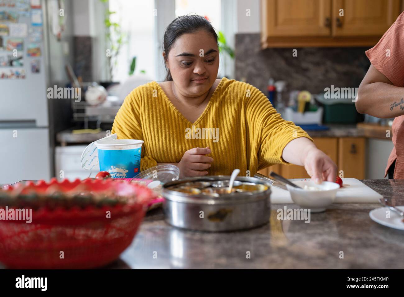 Young woman with down syndrome preparing food in kitchen Stock Photo ...