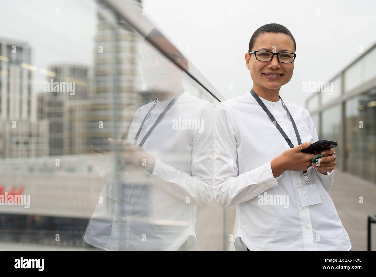 Non binary office worker posing against office buildings Stock Photo ...