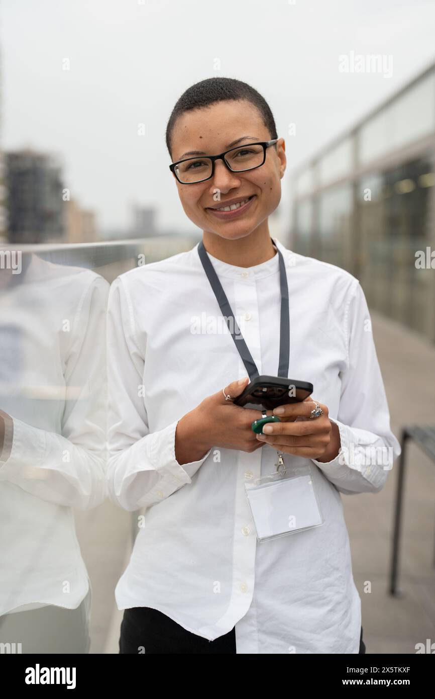 Non binary office worker posing against office buildings Stock Photo ...