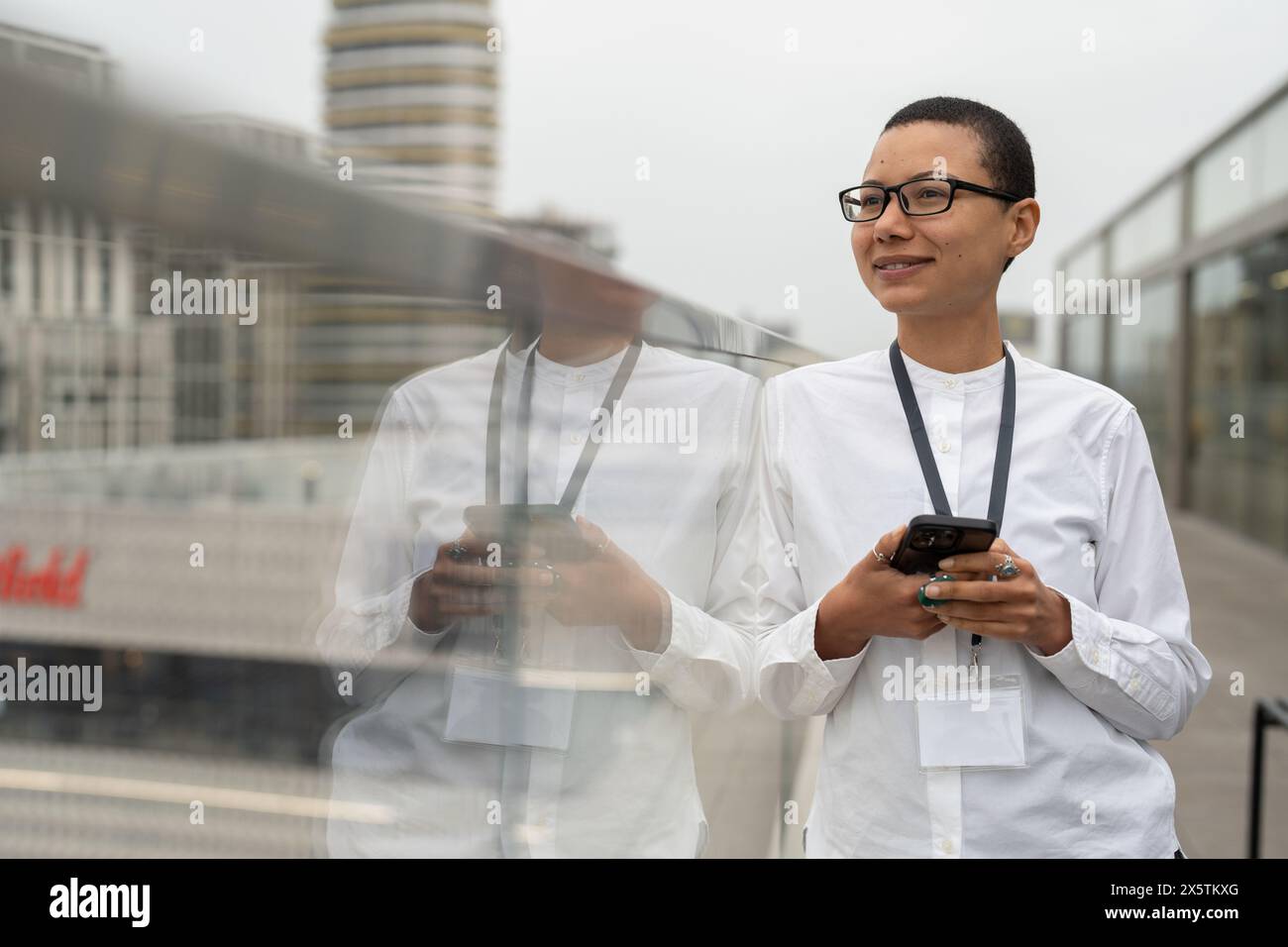 Non binary office worker posing against office buildings Stock Photo ...