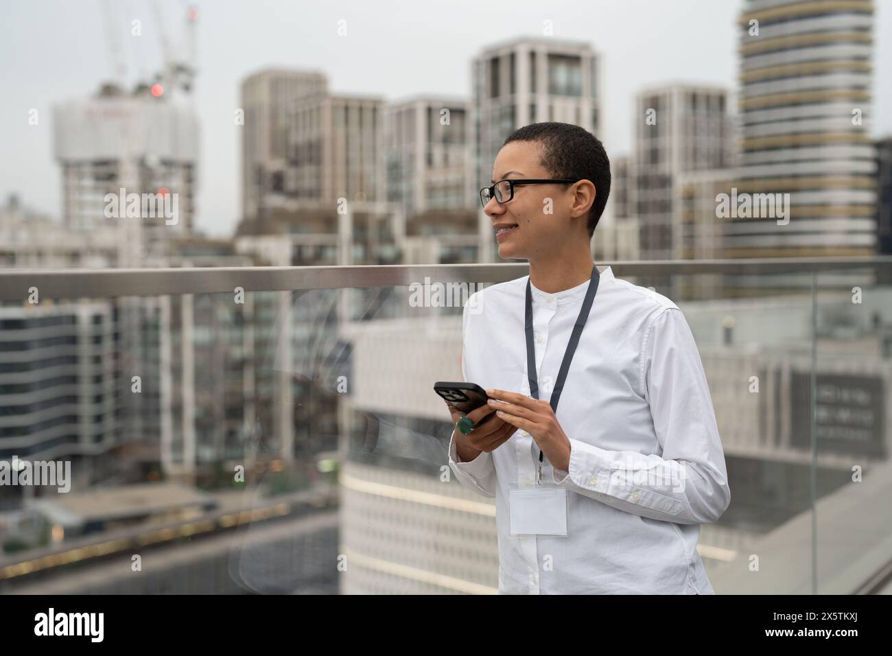 Non binary office worker posing against office buildings Stock Photo ...