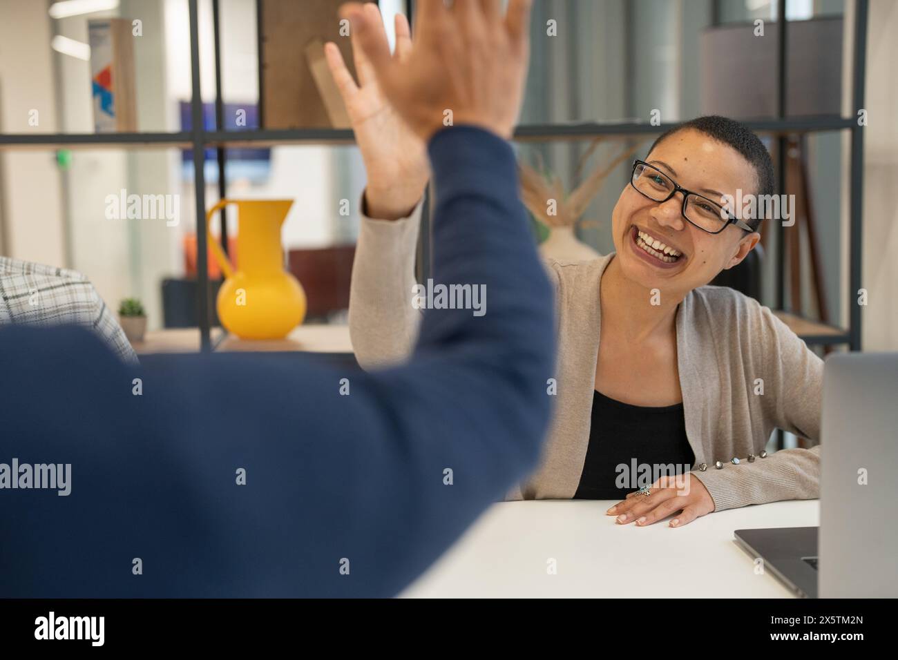 Business people high-fiving in office Stock Photo - Alamy