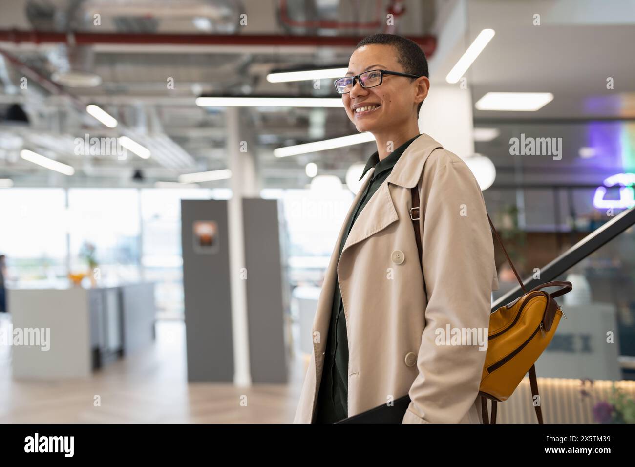 Non binary office worker walking in hallway Stock Photo - Alamy