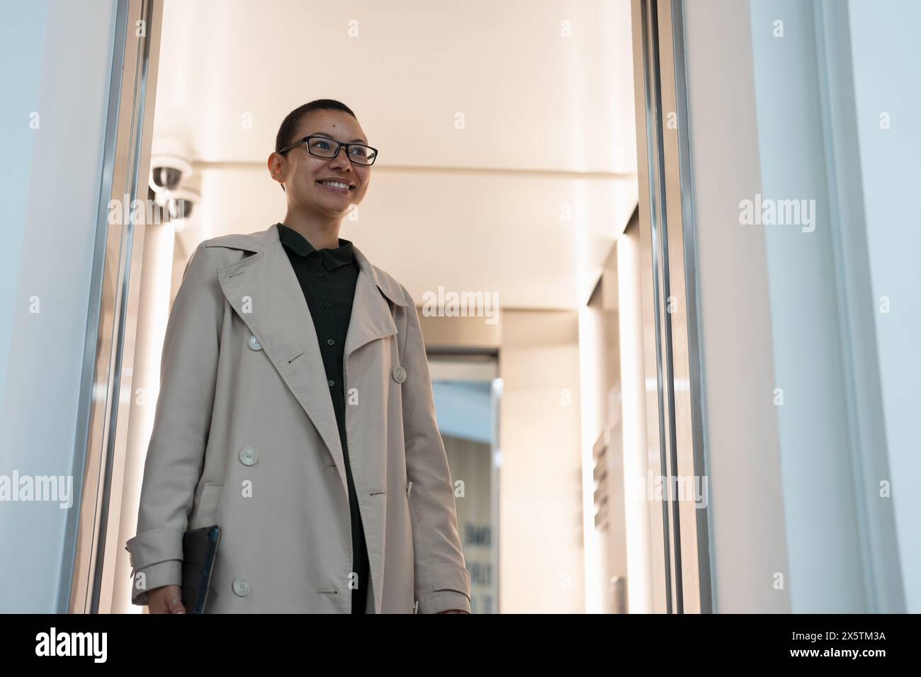 Non binary office worker walking in hallway Stock Photo - Alamy