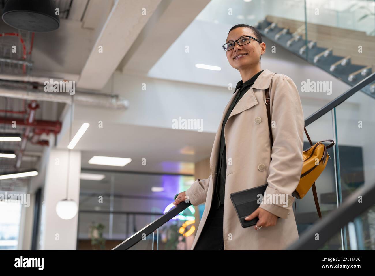 Non binary office worker walking on steps Stock Photo - Alamy