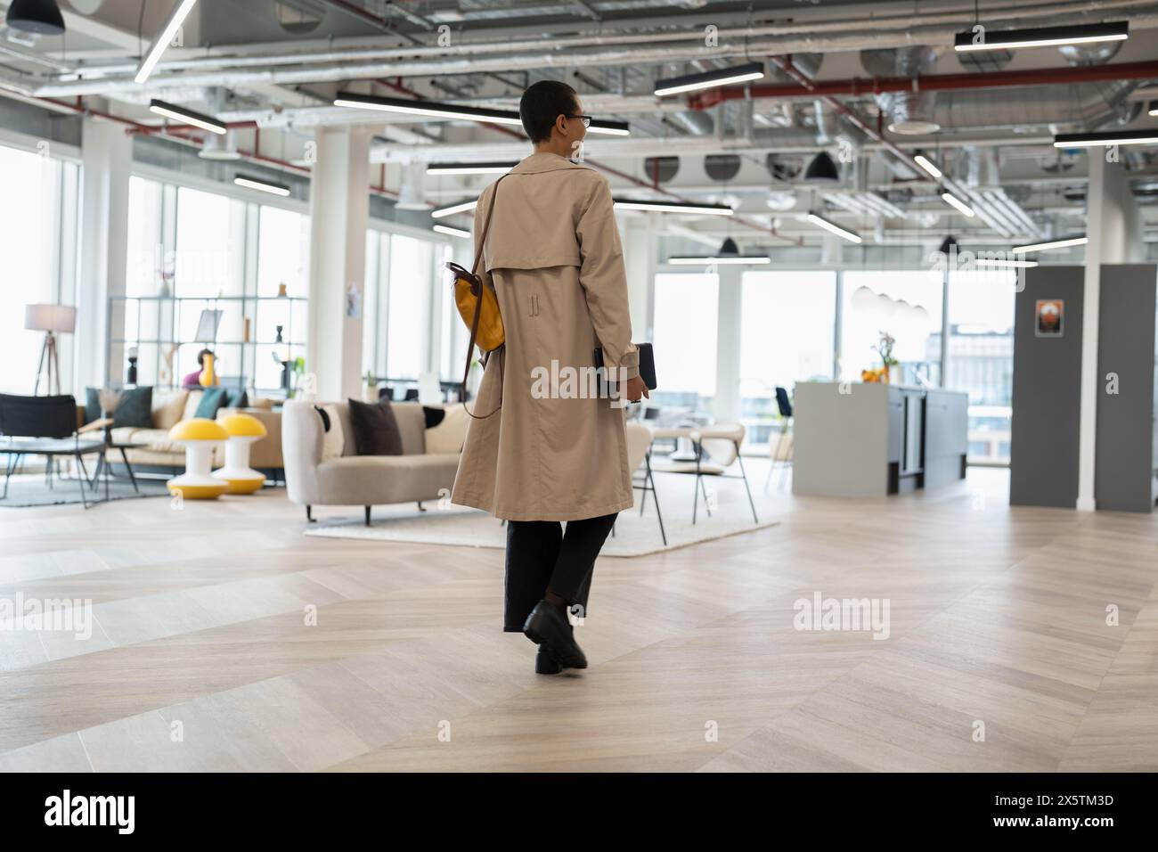 Non binary office worker walking in hallway Stock Photo - Alamy