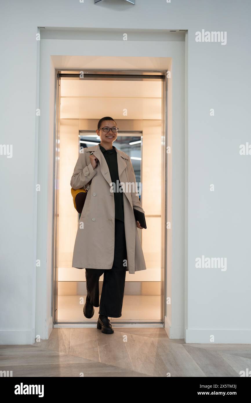 Non binary office worker walking in hallway Stock Photo - Alamy