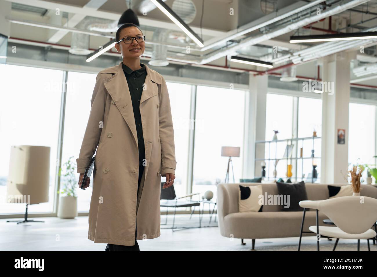 Non binary office worker walking in hallway Stock Photo - Alamy
