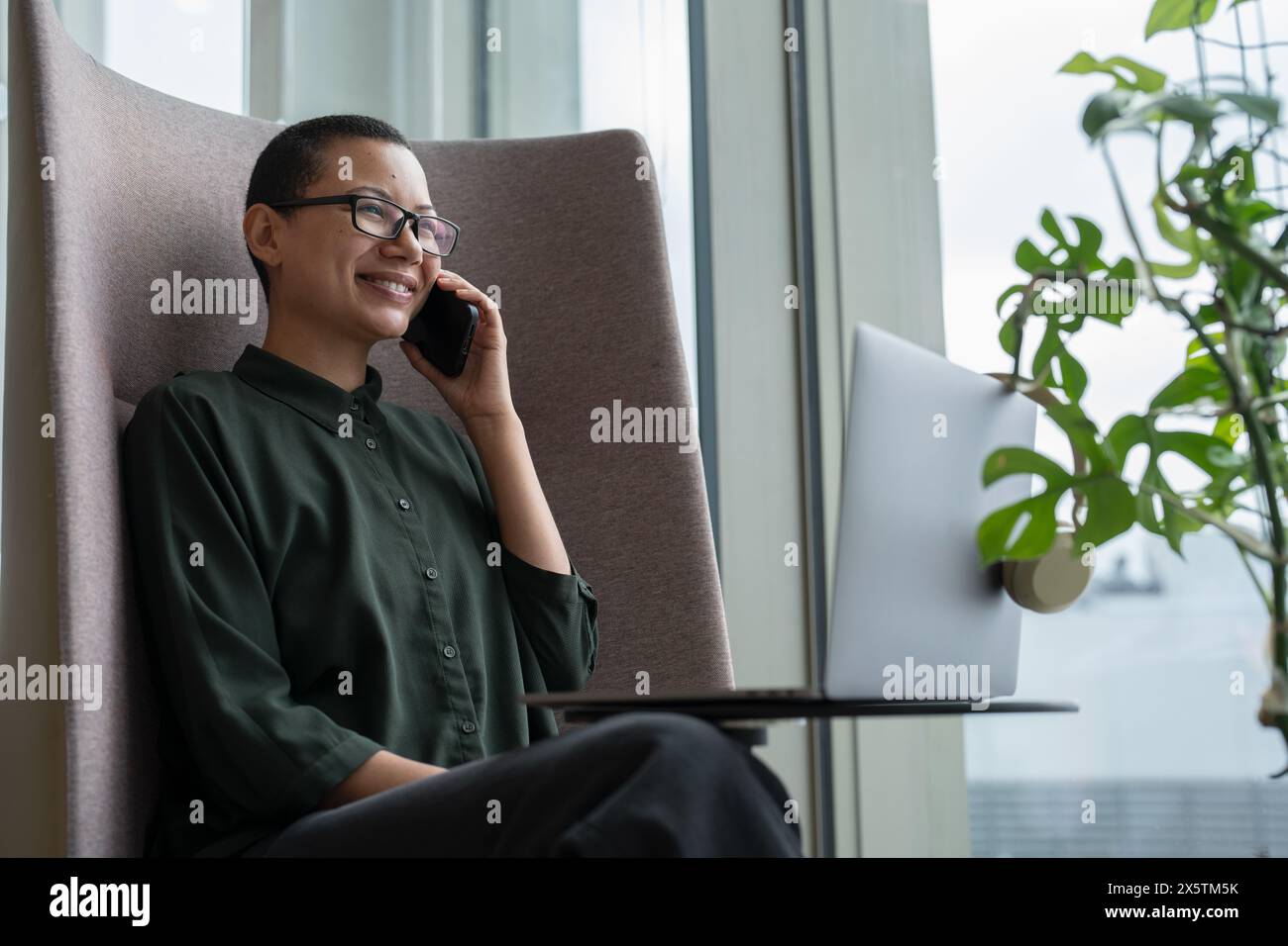 Non binary office worker resting in office lobby Stock Photo - Alamy