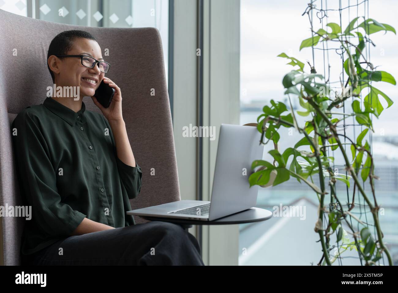 Non binary office worker resting in office lobby Stock Photo - Alamy